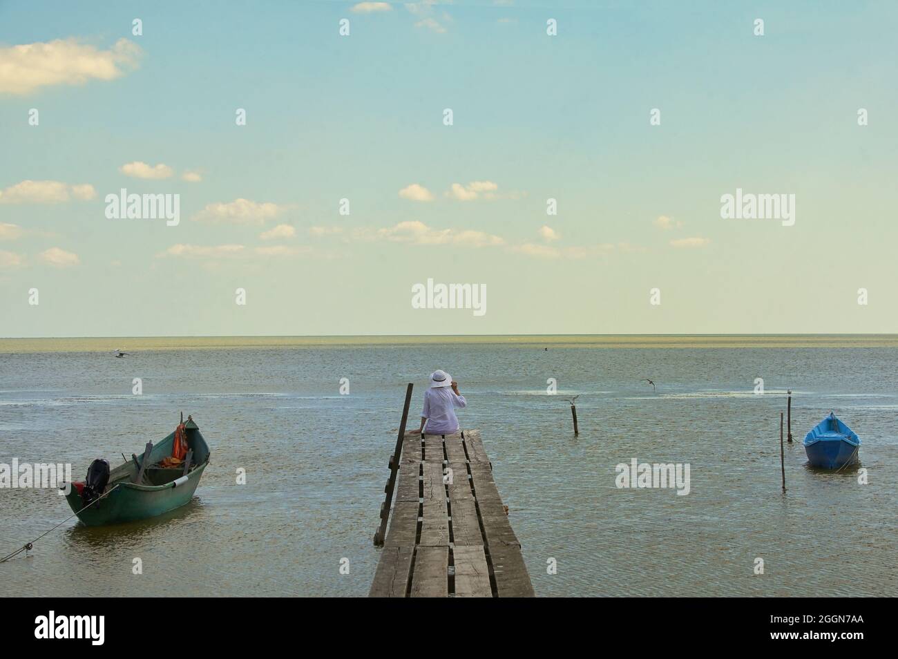 Old Rowboats and Woman On Pier at Razim Lake, Romania Stock Photo - Alamy