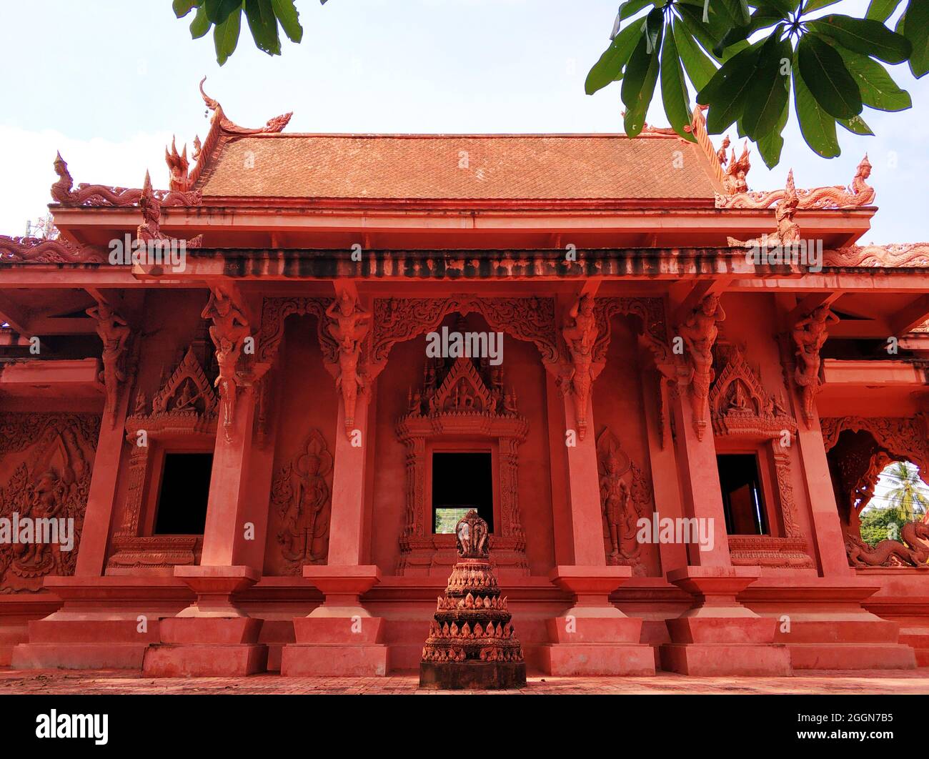 Temple of red color in Thailand. The facade of the temple is decorated ...