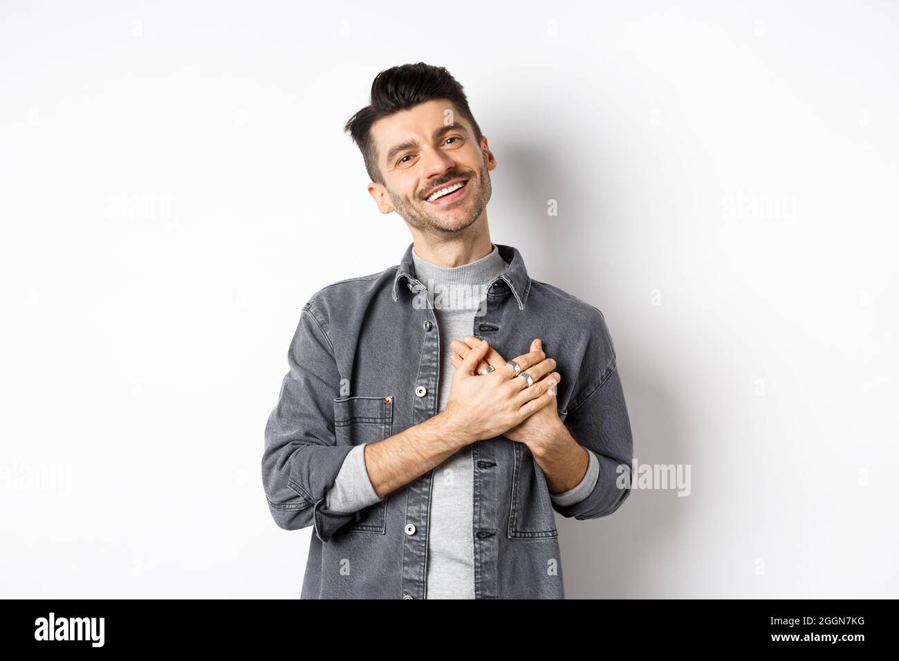 Romantic guy hold hands on heart and smiling, thanking you, looking ...