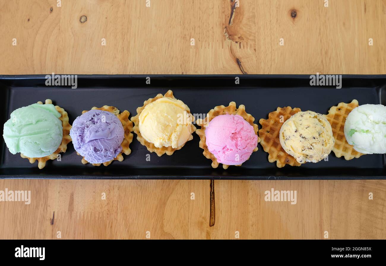 Multi colored and multi flavored ice cream on pieces of waffle. Top ...