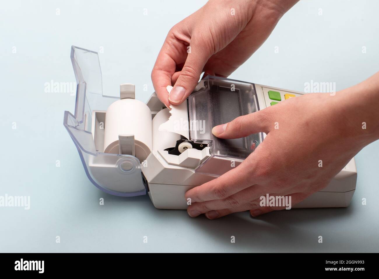 Hands of a young woman repair cash register, insert cash register tape ...