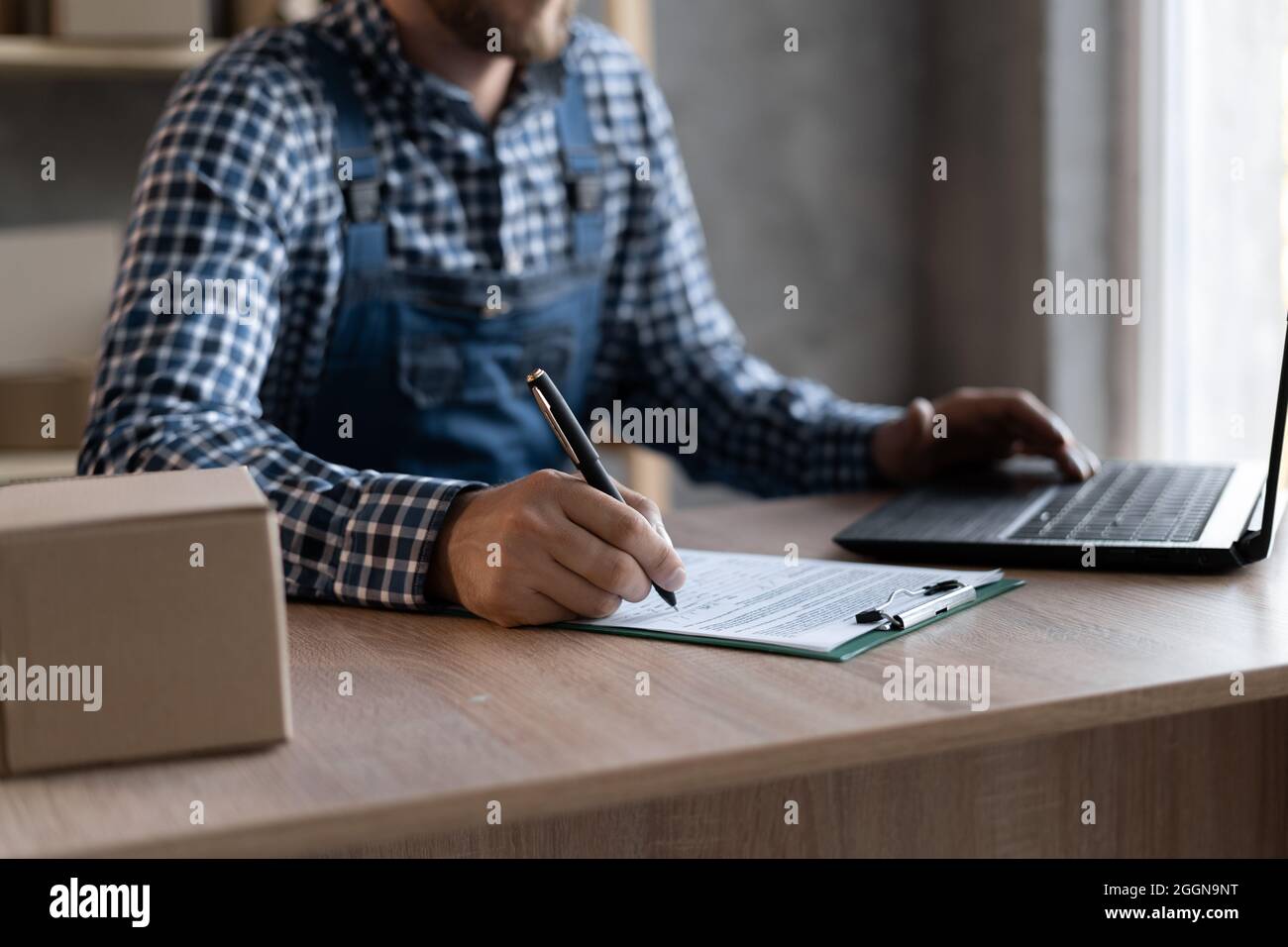 Close-up of a man's hands of a business owner, giving a mark with a pen ...
