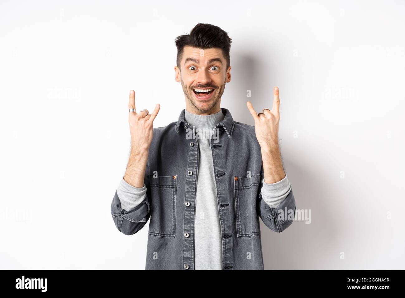 Happy and excited guy showing rock on gesture and having fun, enjoying ...