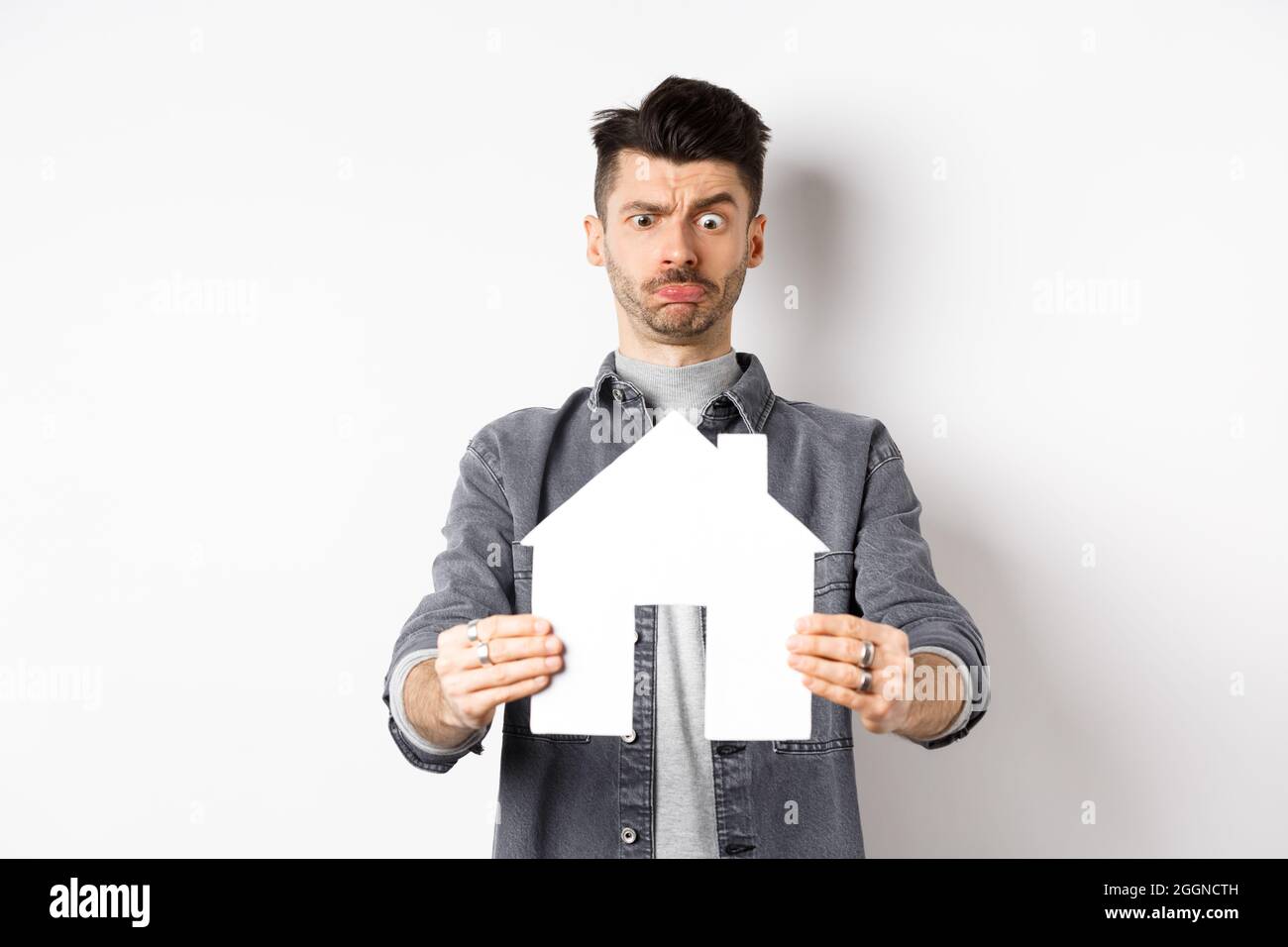 Real estate and insurance concept. Confused guy look at paper house ...