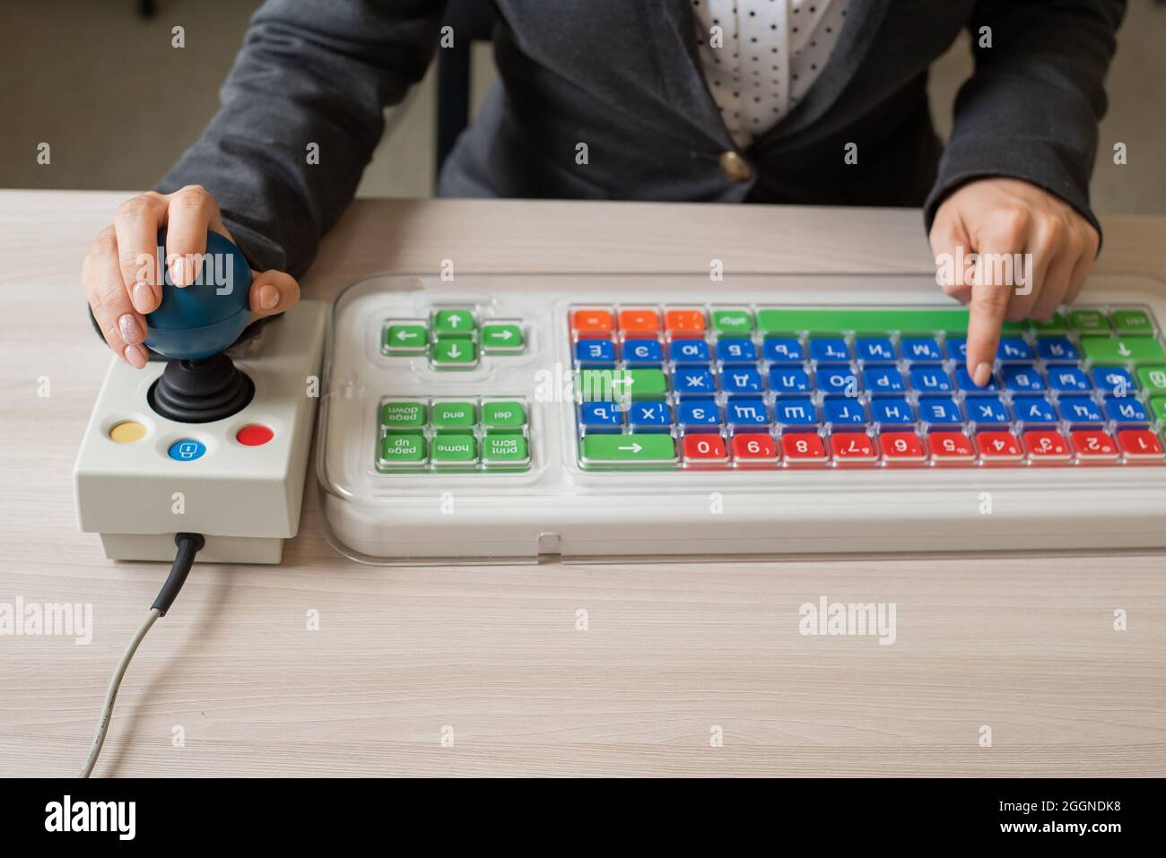 An unrecognizable woman with cerebral palsy is typing on the keyboard ...