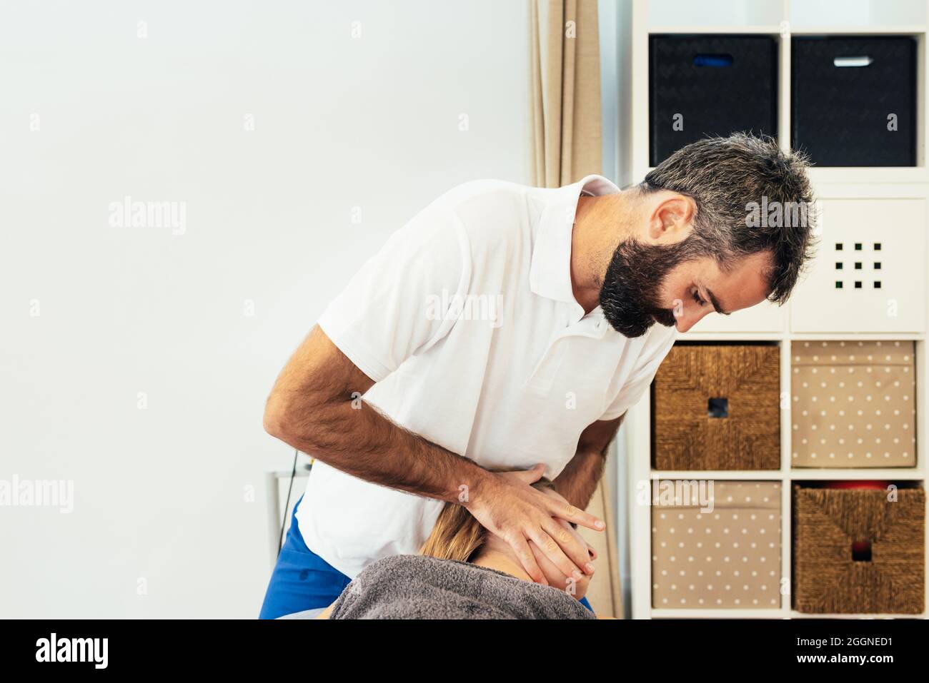 Bearded physiotherapist treating a patient for pain Stock Photo - Alamy