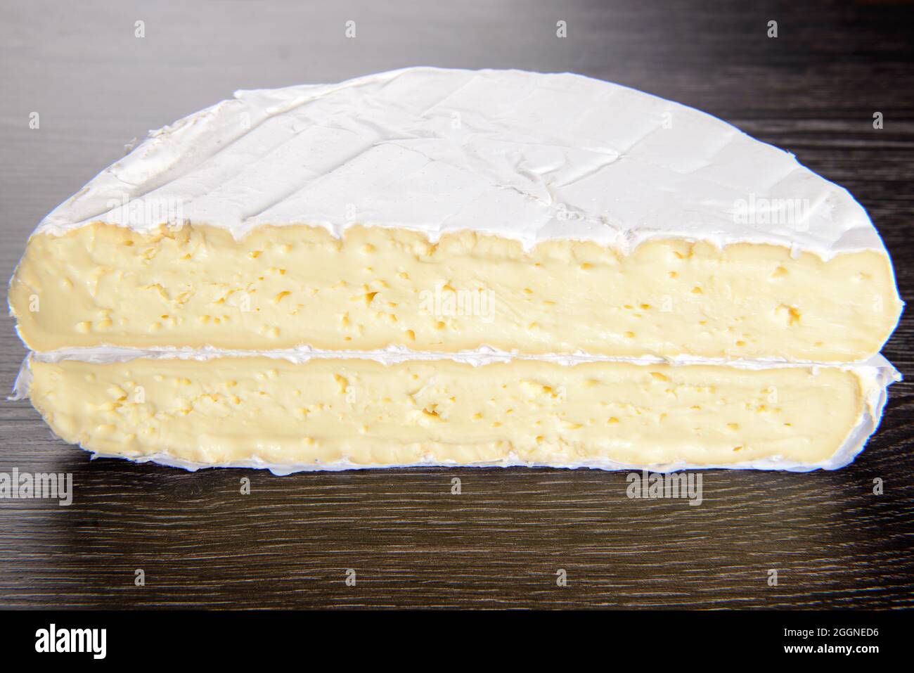 a piece of brie cheese cut in half Stock Photo - Alamy