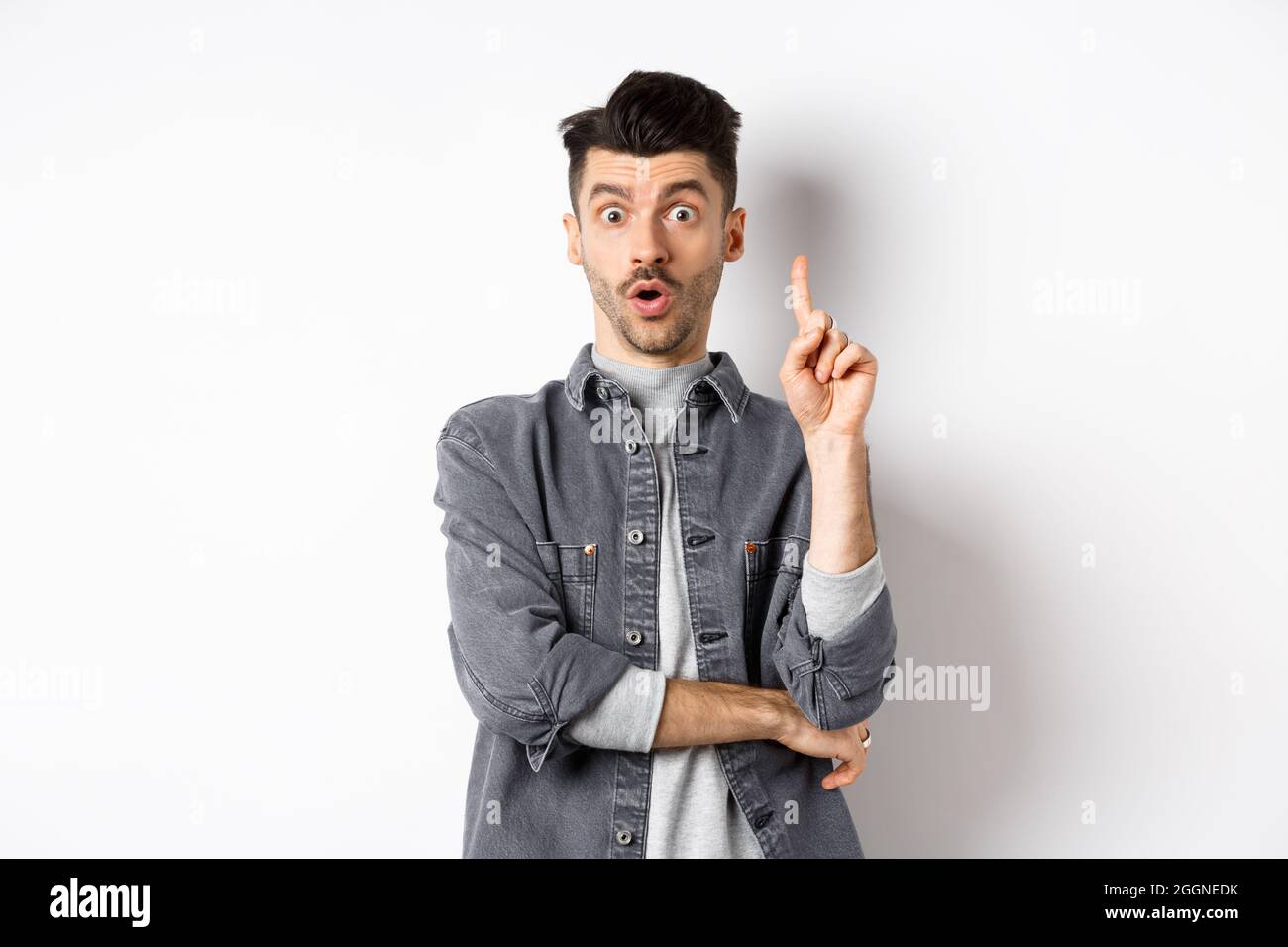 Excited bearded guy pitching an idea, raising finger up in eureka ...