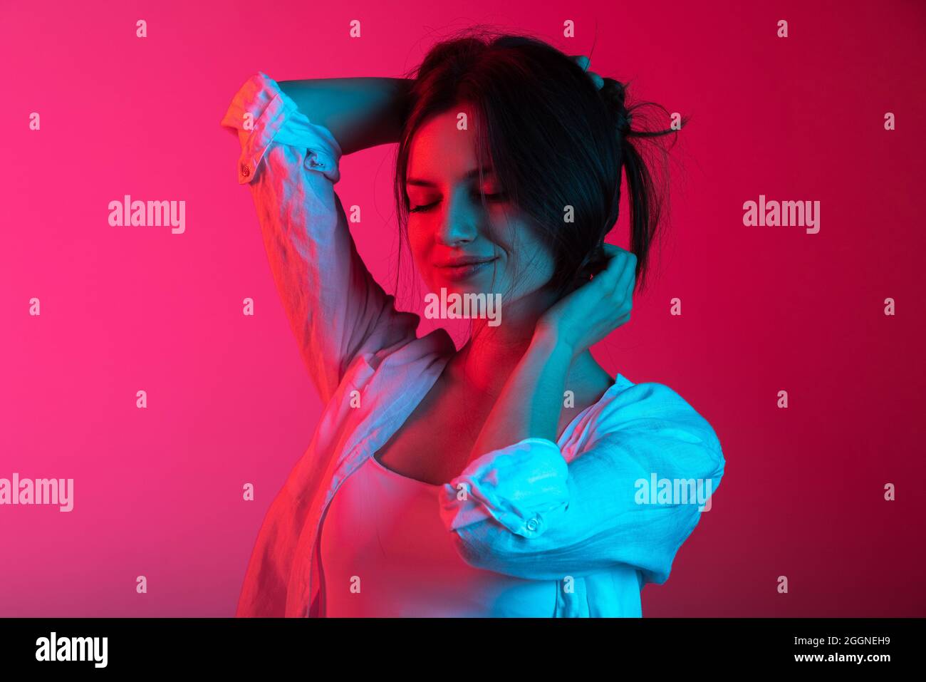 Cropped portrait of young beautiful lady posing on gradient pink red ...