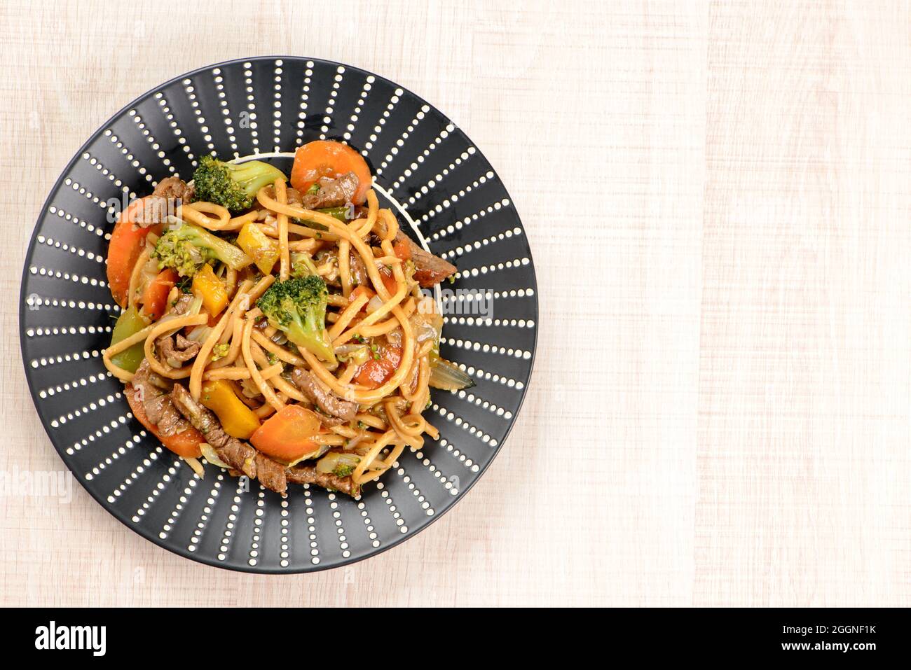 yakisoba on a black plate on a table Stock Photo - Alamy