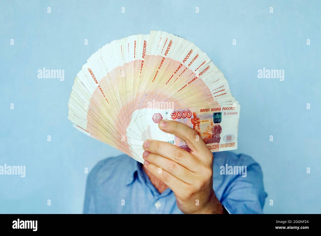 Russian banknotes rubles in hand. 5000 banknotes folded fan cover the ...