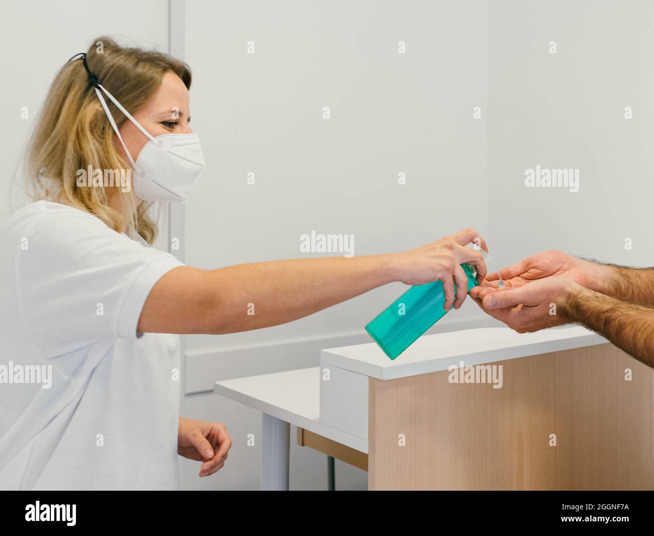 Group of people using hydroalcoholic gel at the entrance of a public ...
