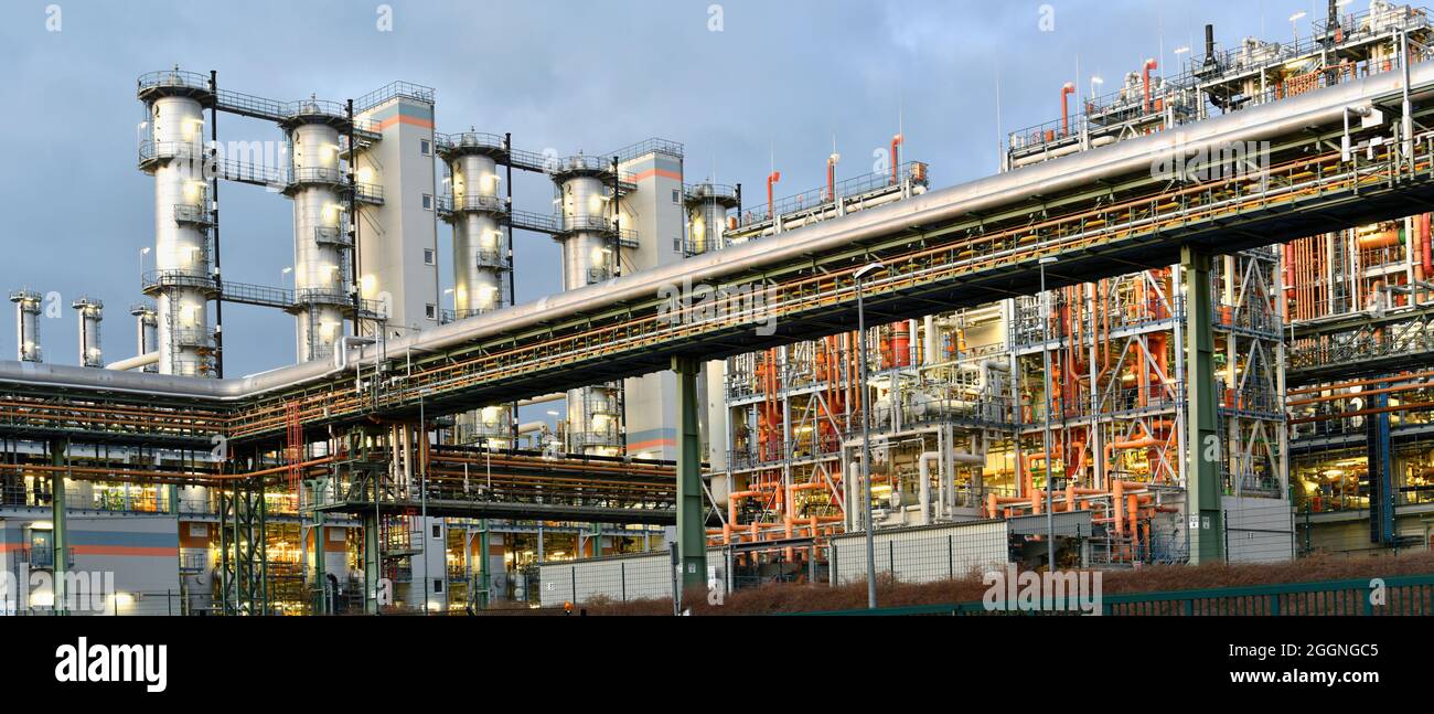 chemical factory at night with buildings, pipelines and lighting ...