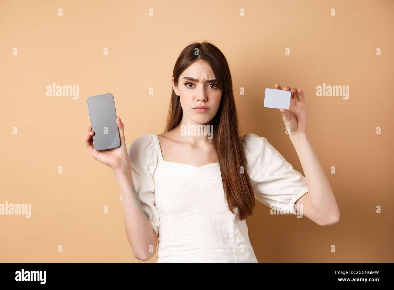Sad and disappointed girl showing empty smartphone screen and plastic ...