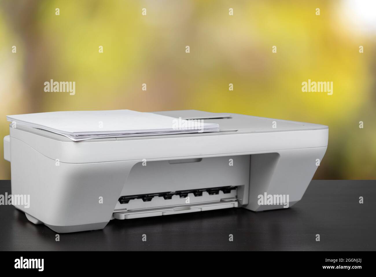 Compact laser printer on black desk against blurred background Stock ...