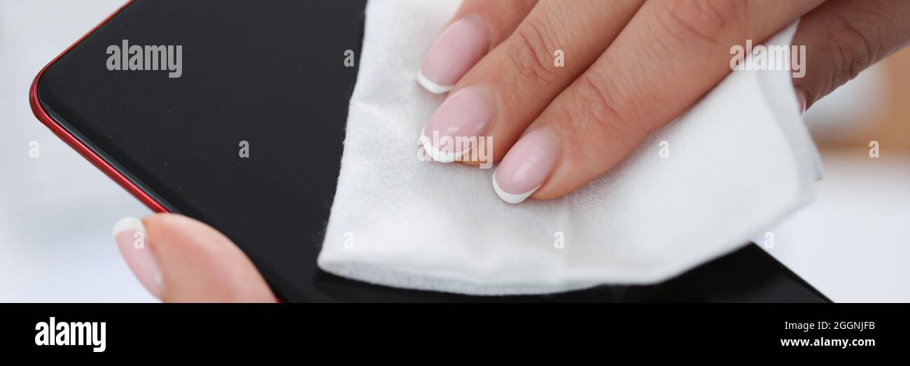 Woman hand wiping screen of mobile phone with damp cloth closeup Stock ...
