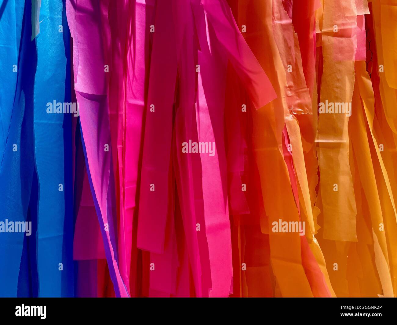 Colored silk ribbons hung in order to form a brightly colored gradient ...