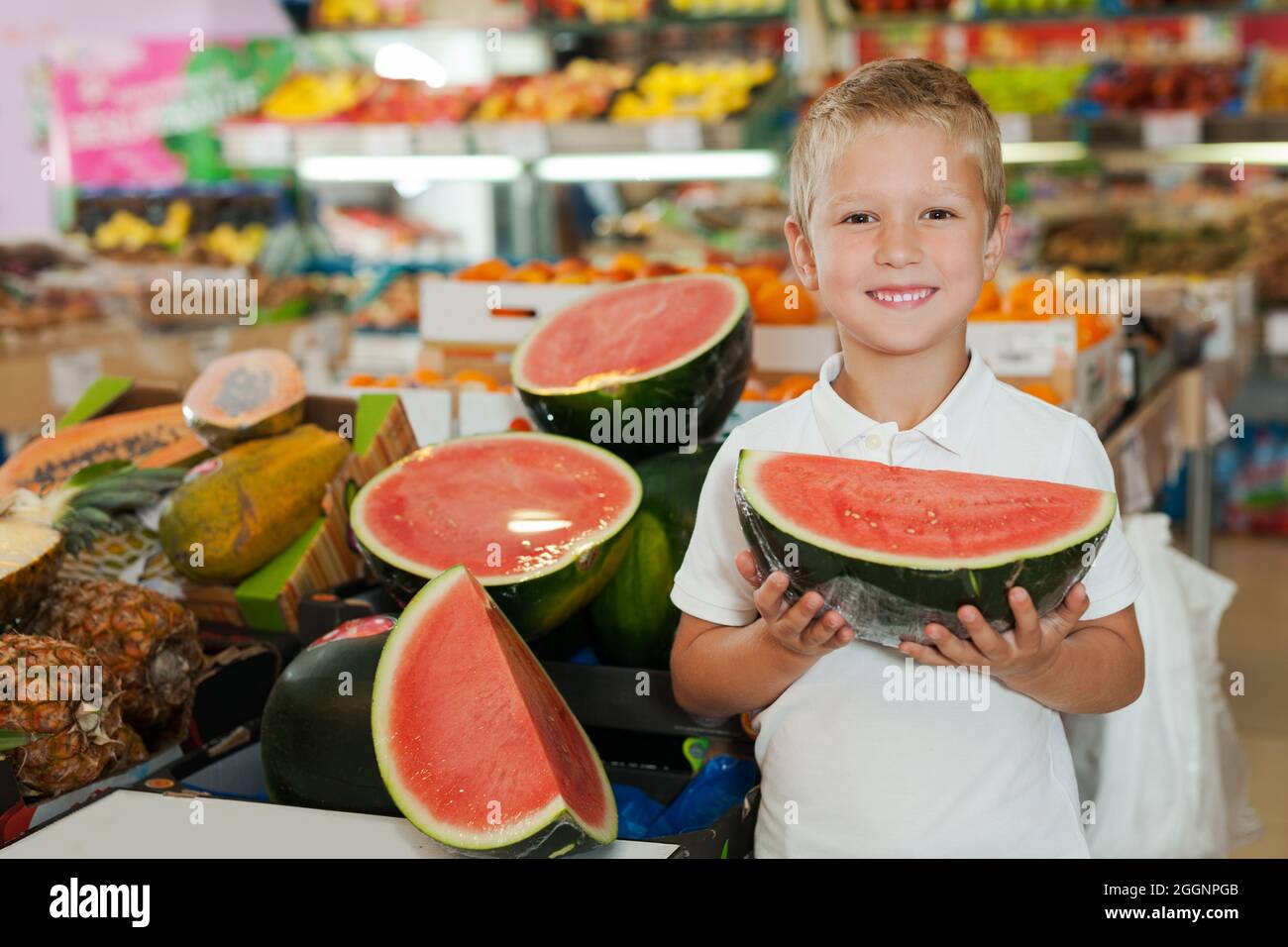 cute cheerful kid holding piece of watermelon at fruit section Stock ...