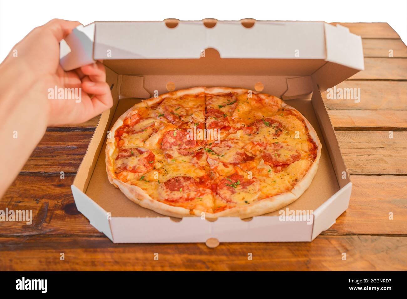 The guy's hand opens a cardboard box of pizza against the background of ...