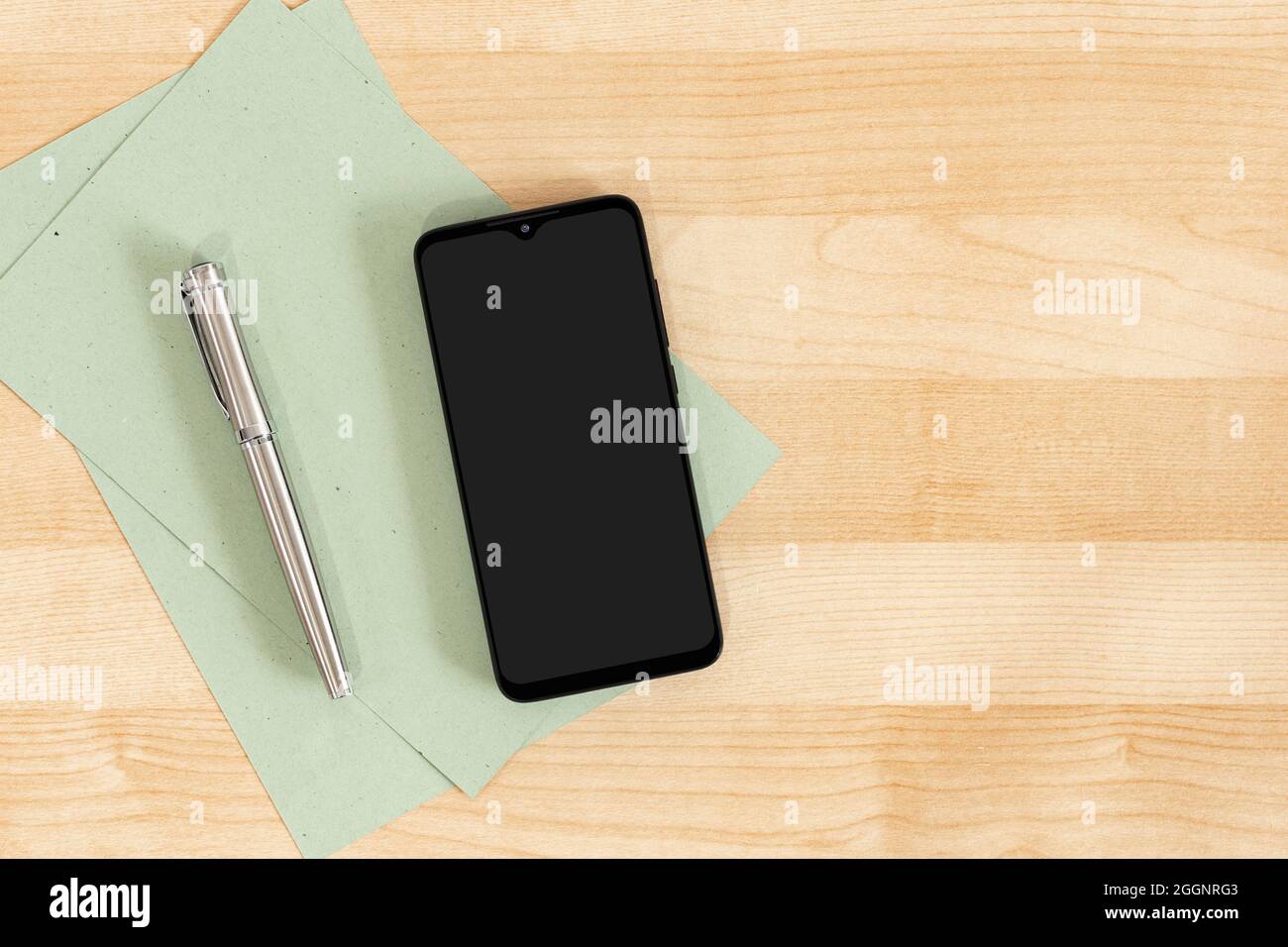 Top view of a notebook phone and a pen on the desk Stock Photo - Alamy