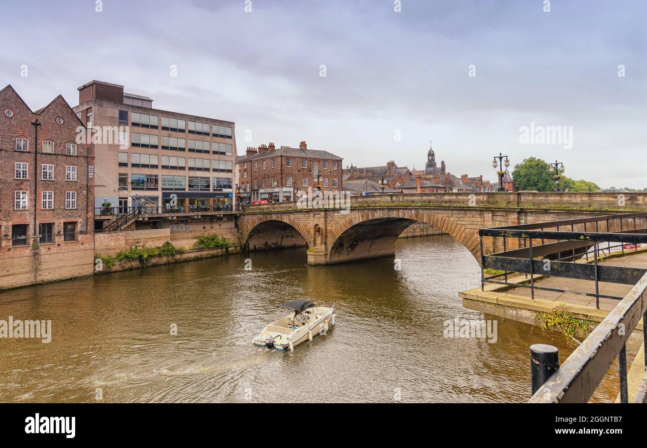 A 19th century stone bridge spanning a river. Buildings are on the far ...