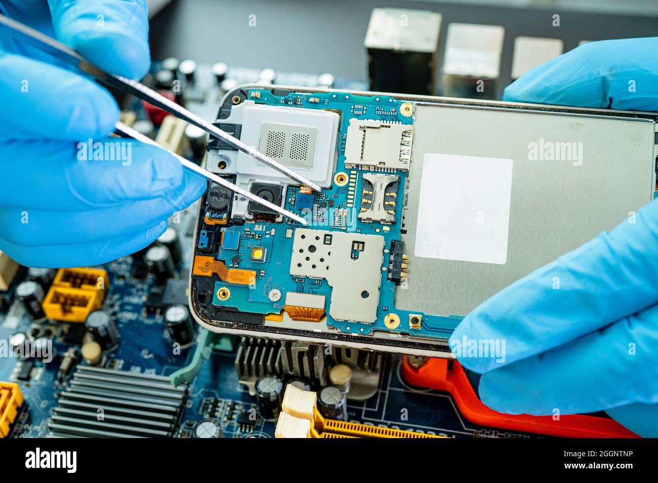 Technician repairing inside of mobile phone by soldering iron ...