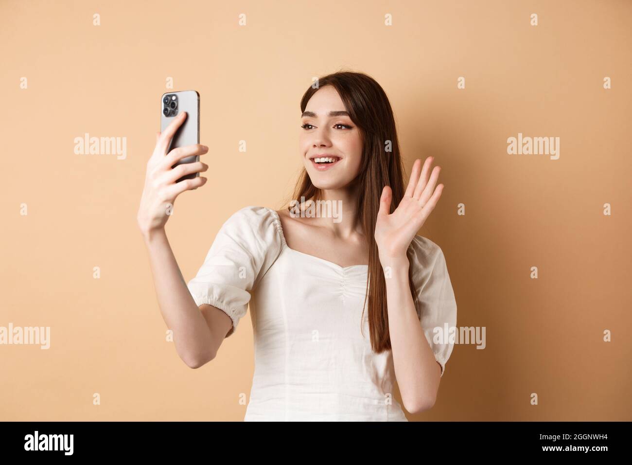 Girl video chat on phone, waiving hand at mobile camera and saying ...