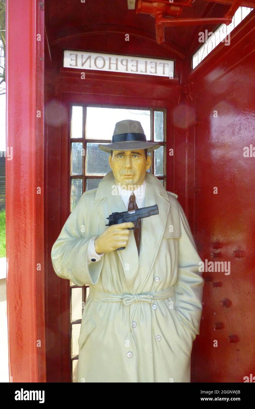 Red telephone box with man and gun Stock Photo - Alamy