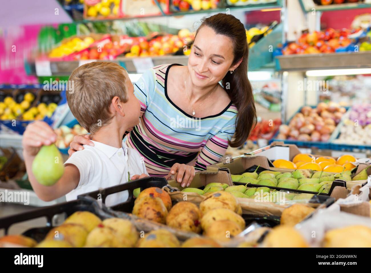 Cheerful mother with little boy buying pears and apples at store Stock ...