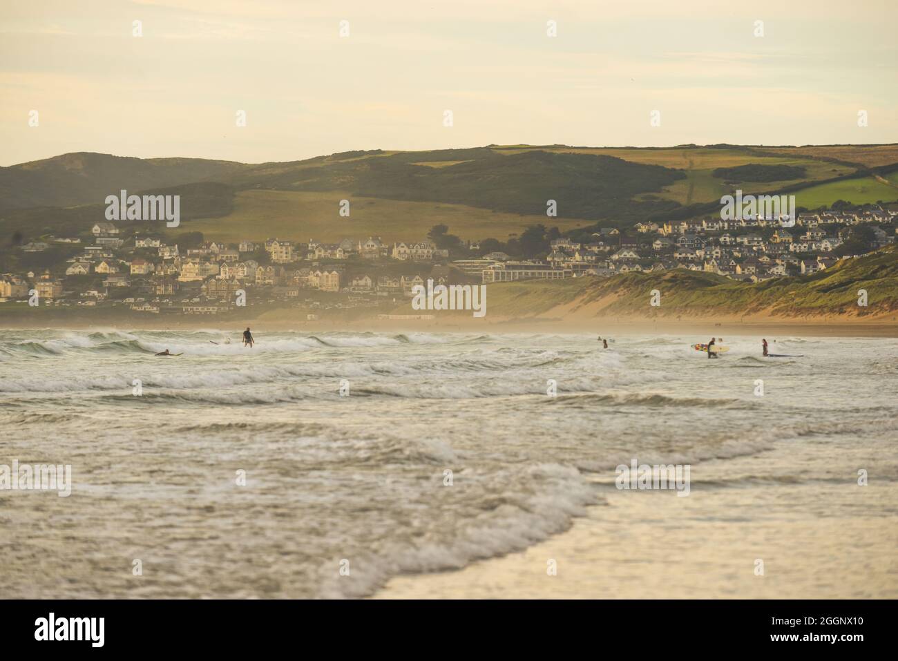 View from the shore at the beach with people surfing ocean waves in the ...