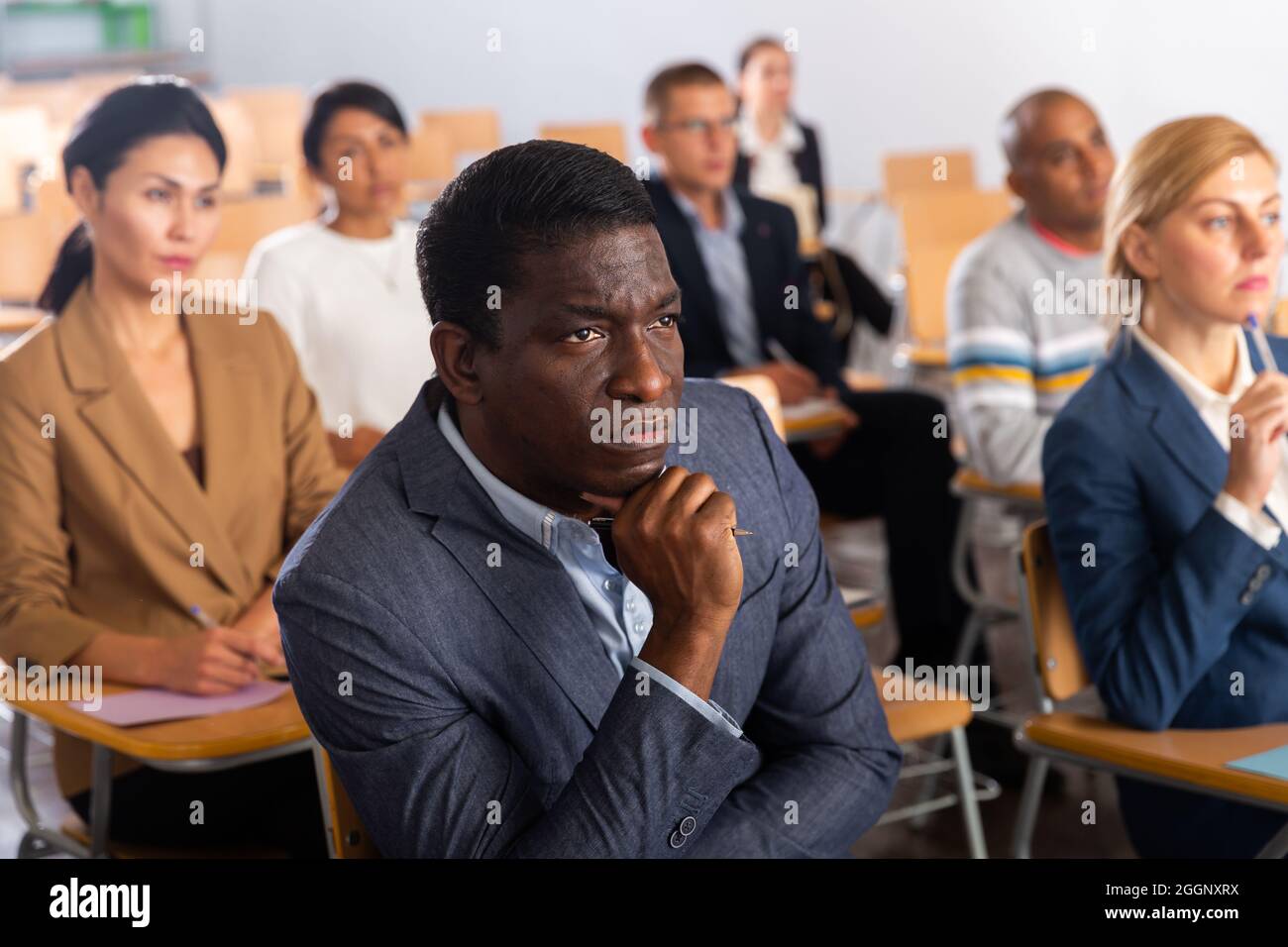 Focused man listening to lecture at conference Stock Photo - Alamy