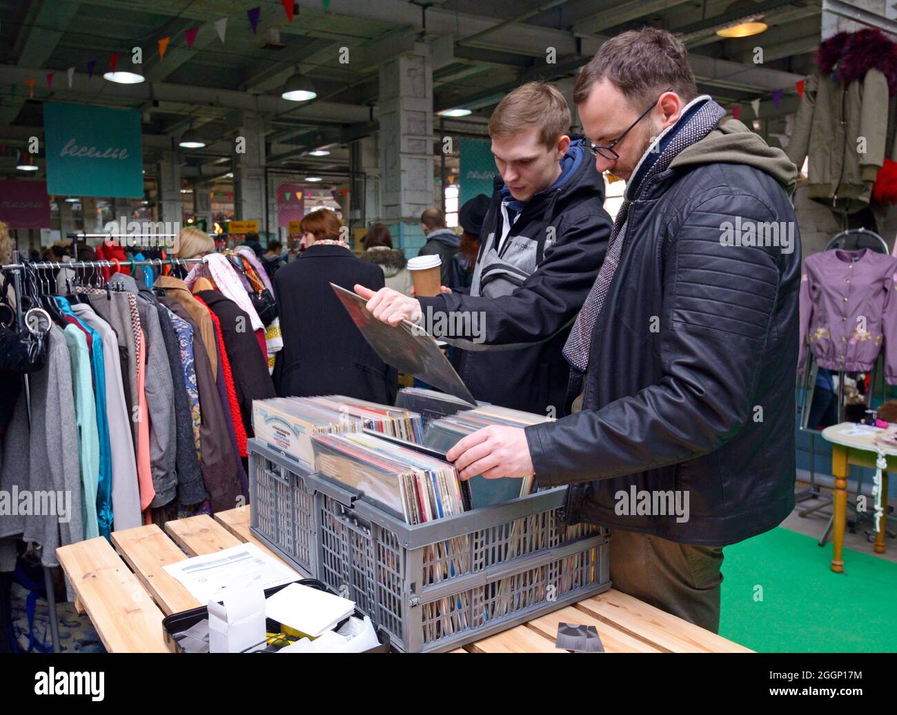 Flea market. Two men standing at the counter buying old records ...
