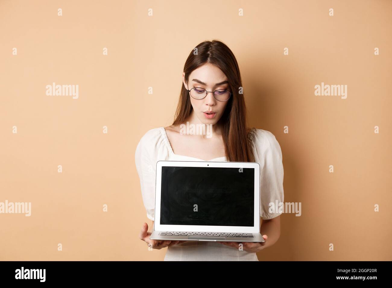 Excited girl in glasses show laptop screen, demonstrate online offer on ...