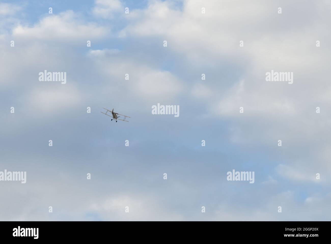 A small vintage biplane flying into clear blue sky Stock Photo - Alamy