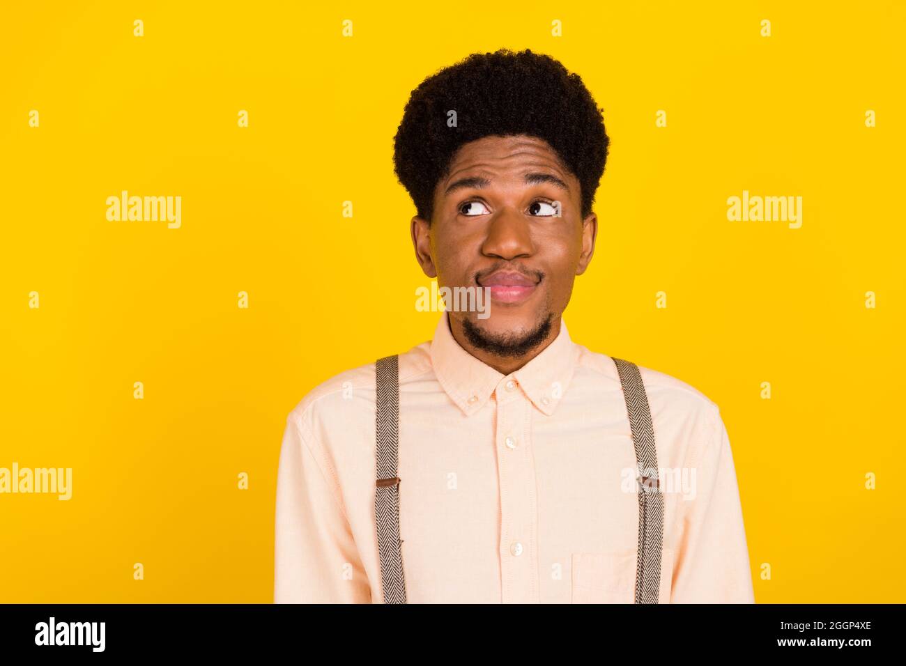 Photo of dreamy shy boyfriend guy look up empty space wear suspenders shirt isolated yellow ...