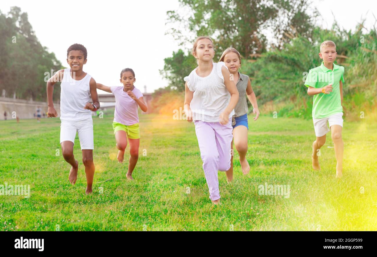 Children running on green grass Stock Photo - Alamy