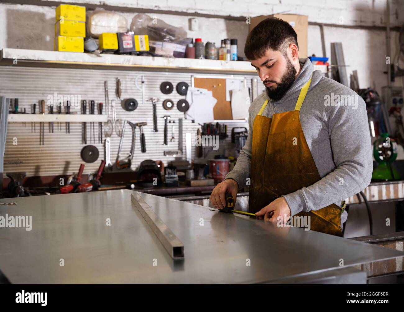 Engineer measures metal sheet with a tape measure Stock Photo - Alamy