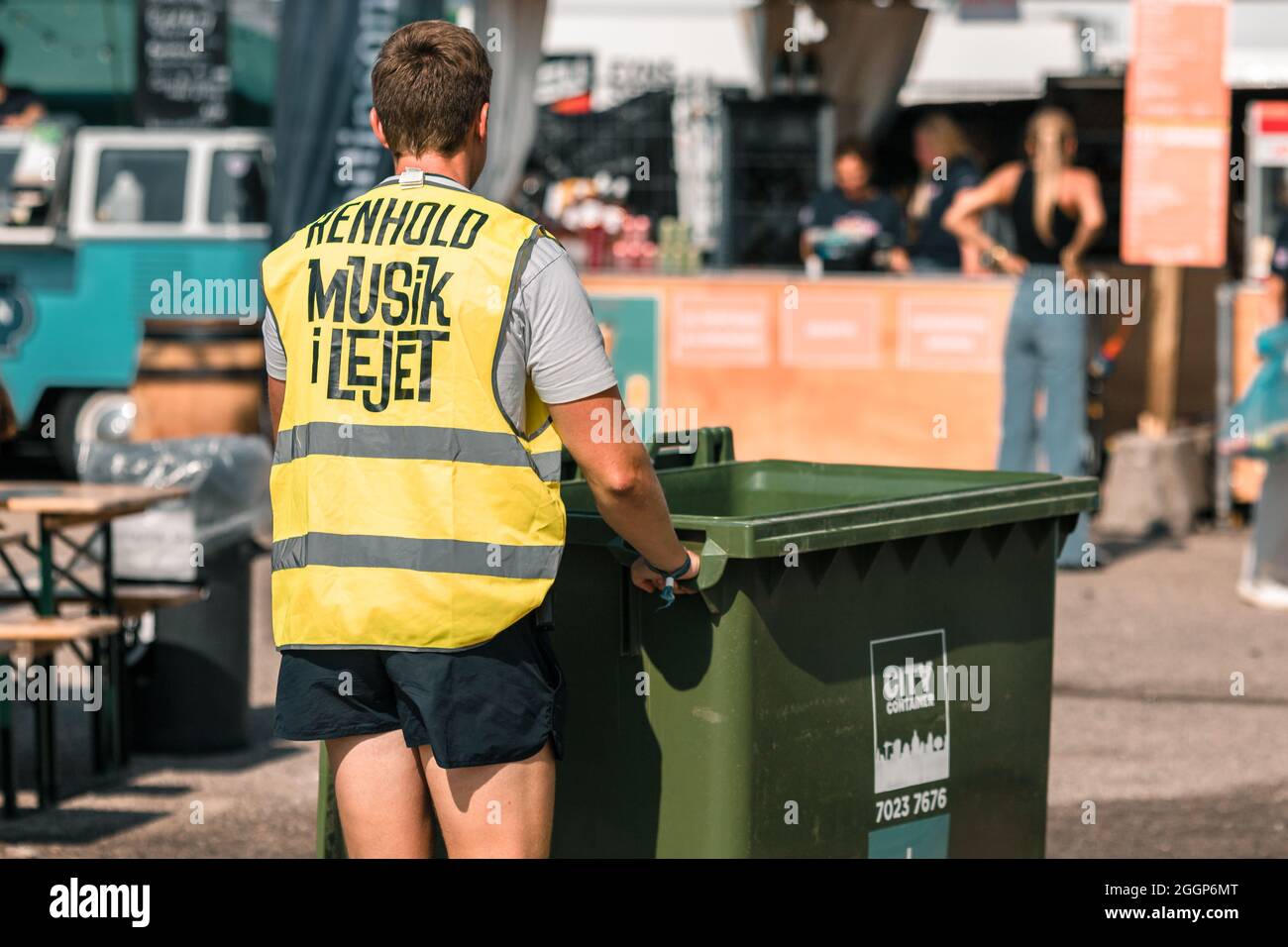 TISVILDELEJ, DENMARK - Jul 23, 2021: A worker carrying a trash bin ...