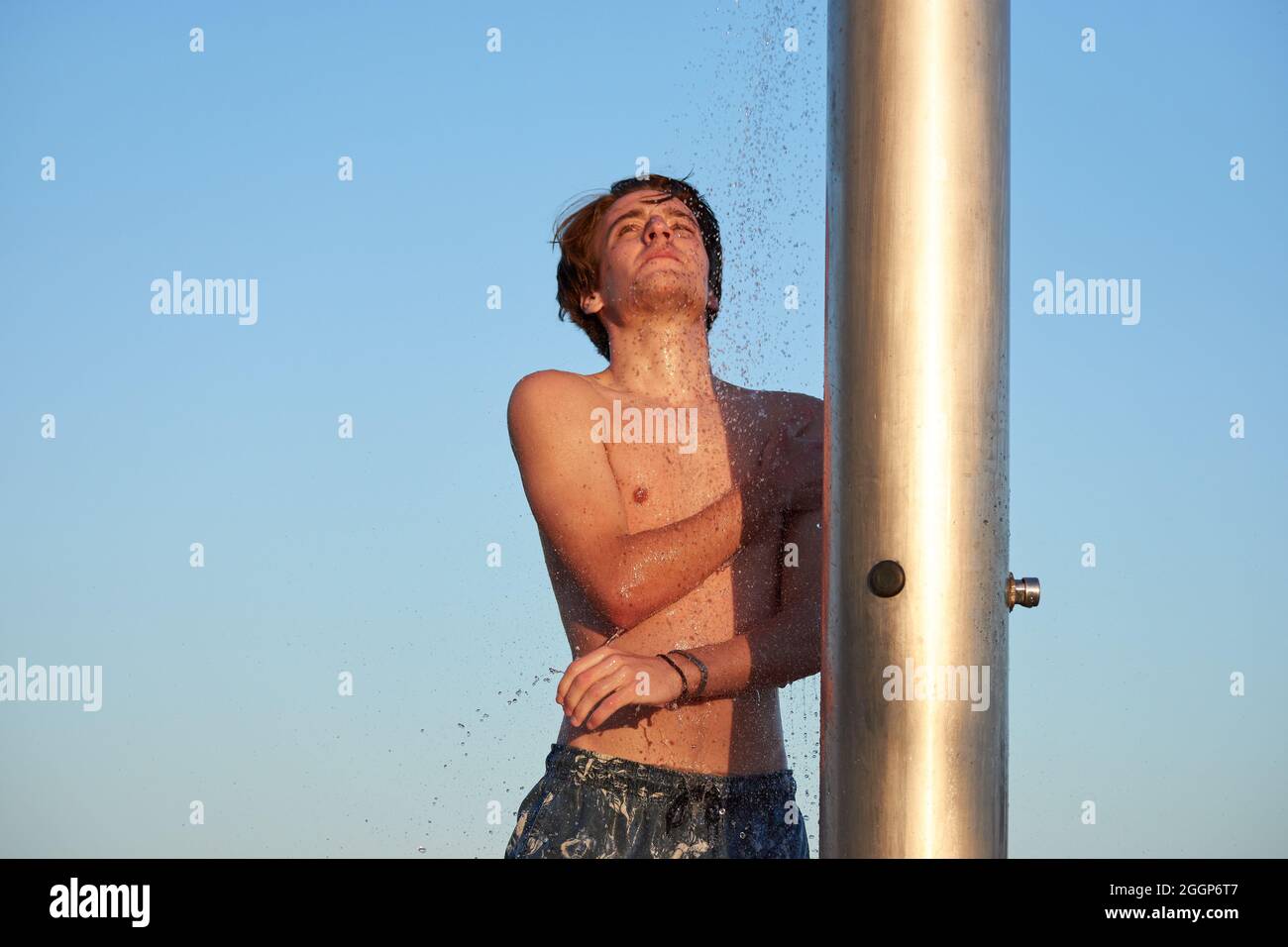Caucasian male taking a shower at a beach during the day Stock Photo - Alamy