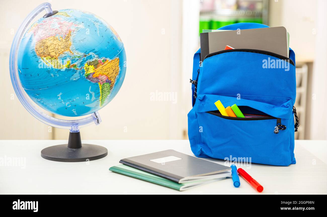 Back to school. Student backpack and supplies on white desk, blur ...