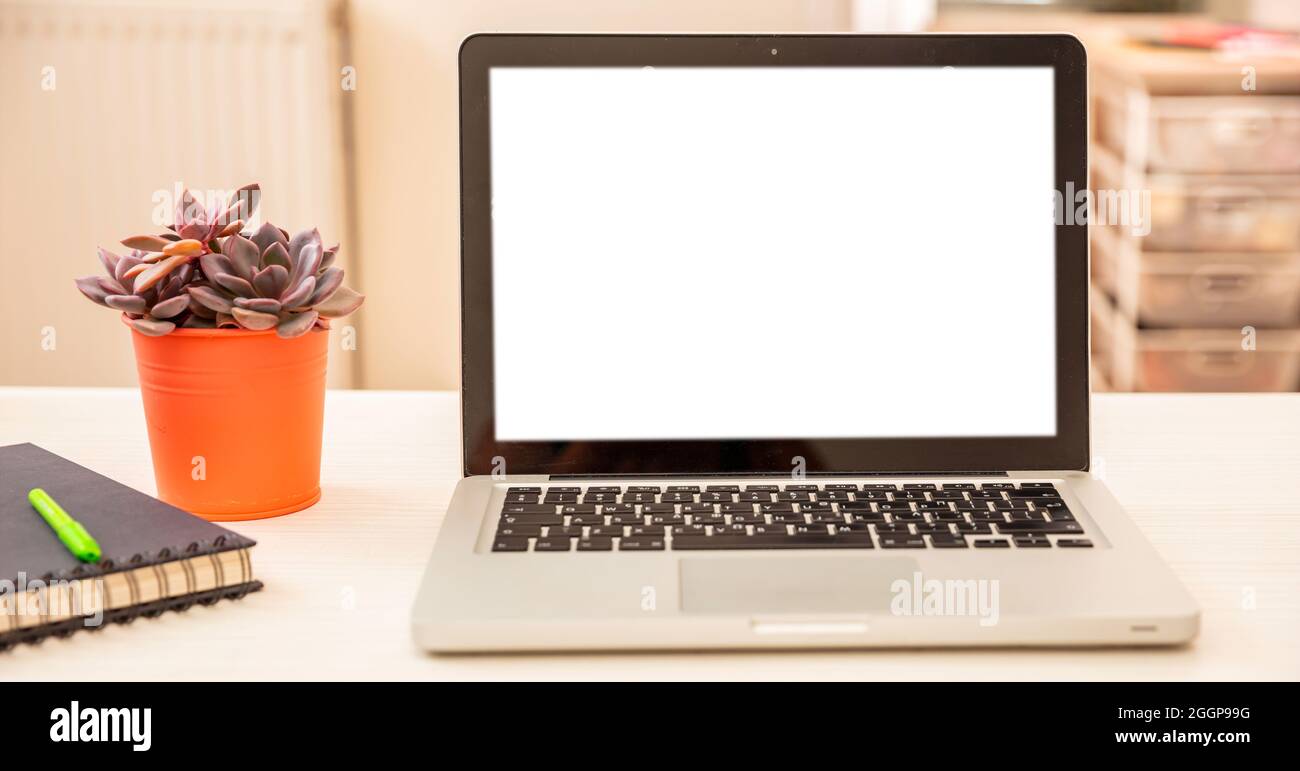 Blank screen computer laptop on a white office desk, blur room interior ...