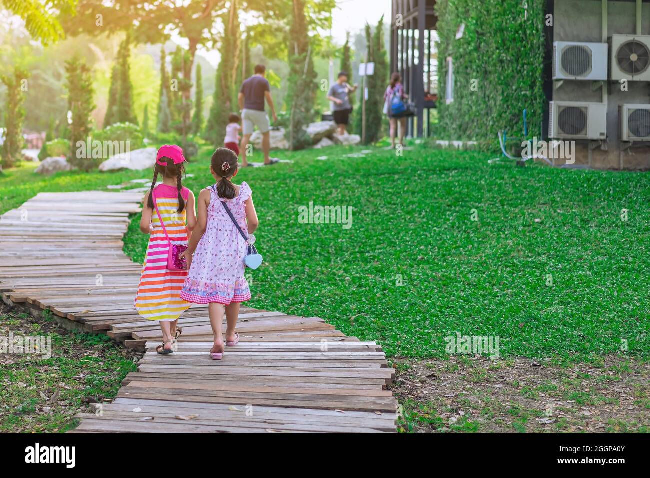 Back view of Asian little girls in dress walking side by side on ...