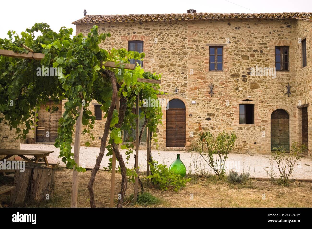 The facade of a rural stone farmhouse with wooden doors and windows in ...