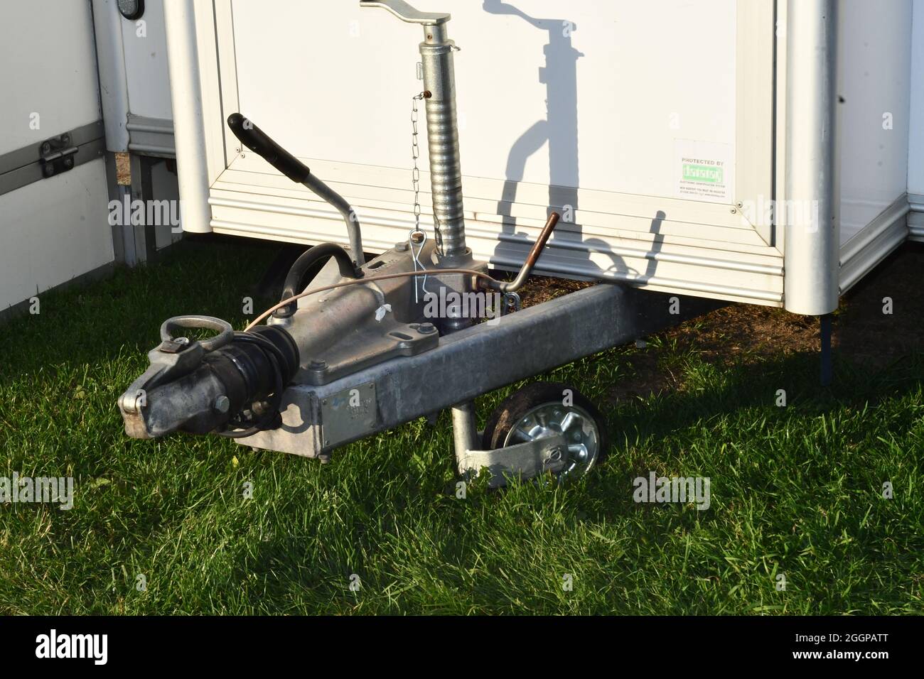 A large white trailers towing arm with winch lever, release lever ...