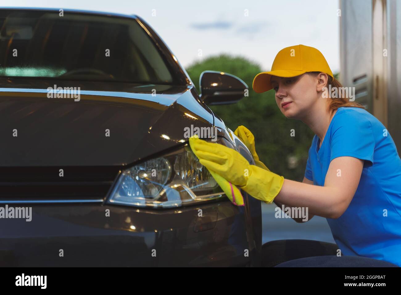 Women in uniform polishing car with rug. Car wash service Stock Photo ...