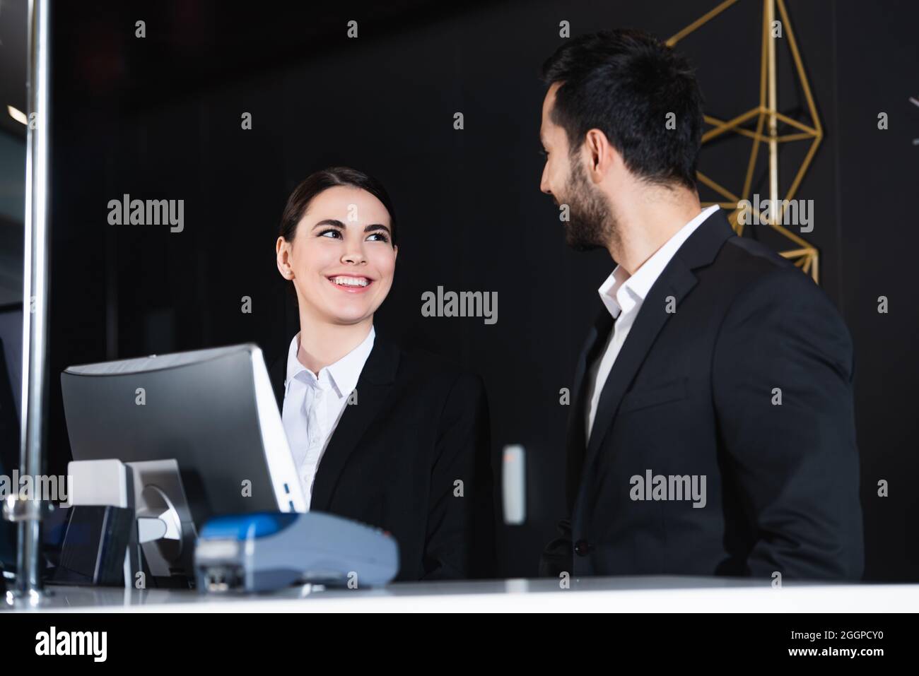 happy administrators looking at each other in front desk Stock Photo ...