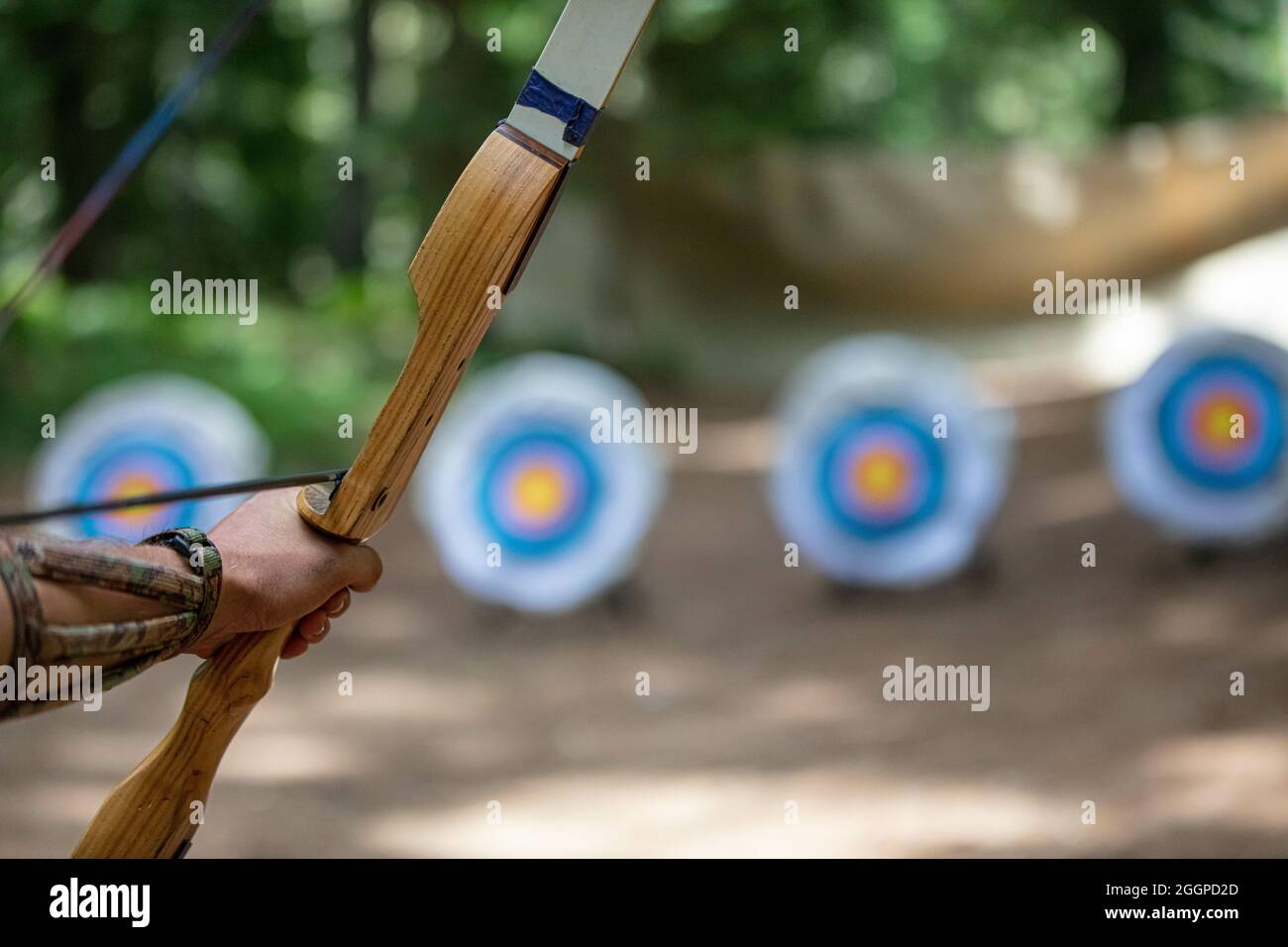 Selective focus of an archer holding his bow aiming at a target Stock ...