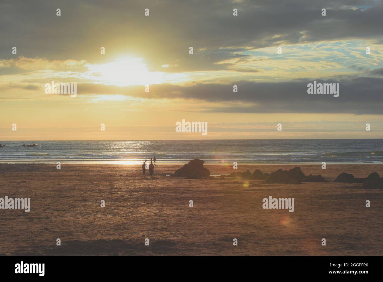Coastal travel destination of a warm beach at sunset with people ...