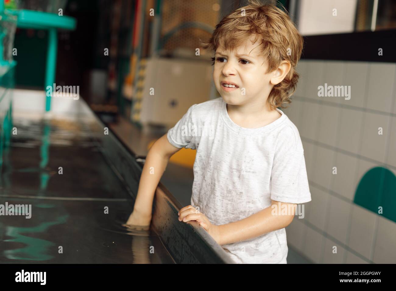 Boy expresses negative emotions while playing with water in children's ...