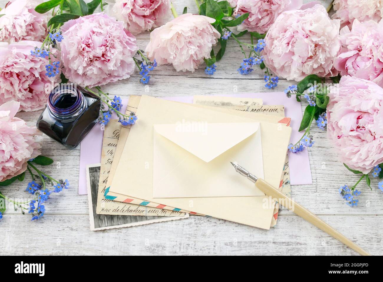 Vintage sheet of paper and pen. Pink peonies and forget me not flowers ...